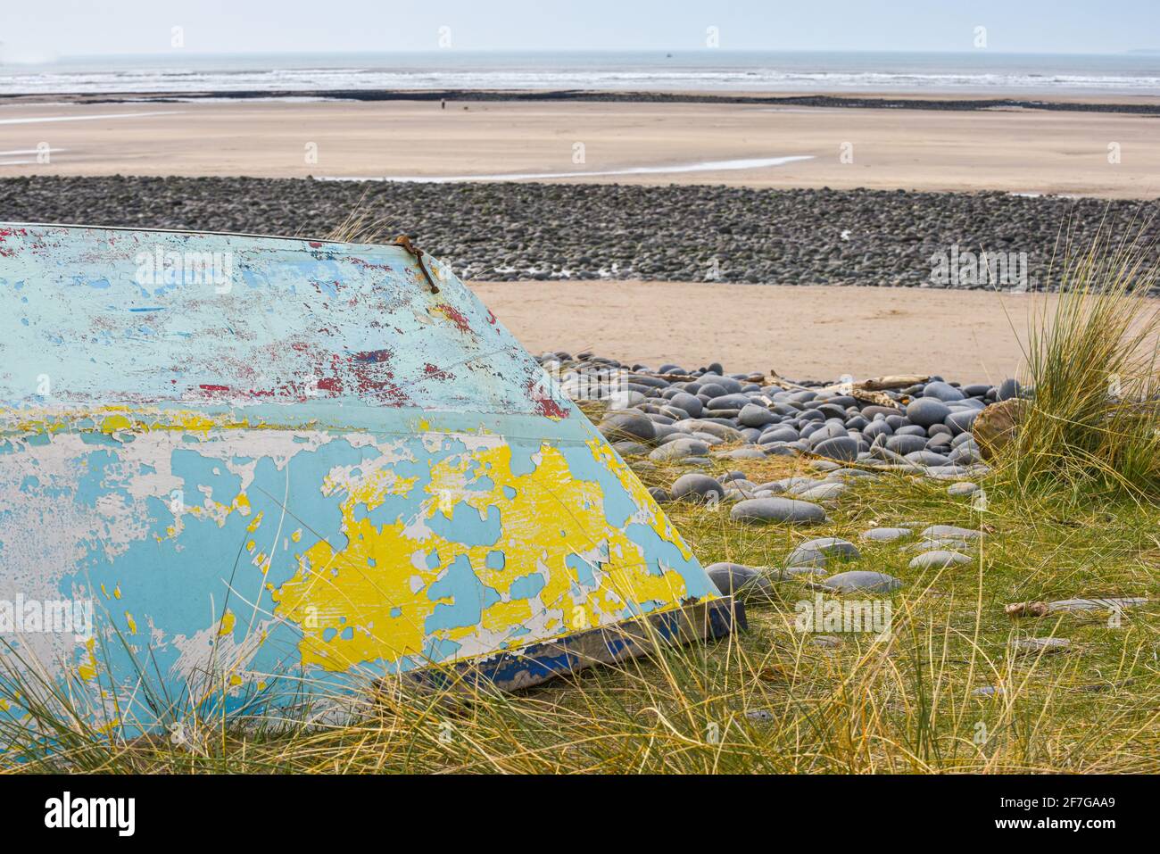 An upturned small boat washed up on the shoreline of a beautiful ...