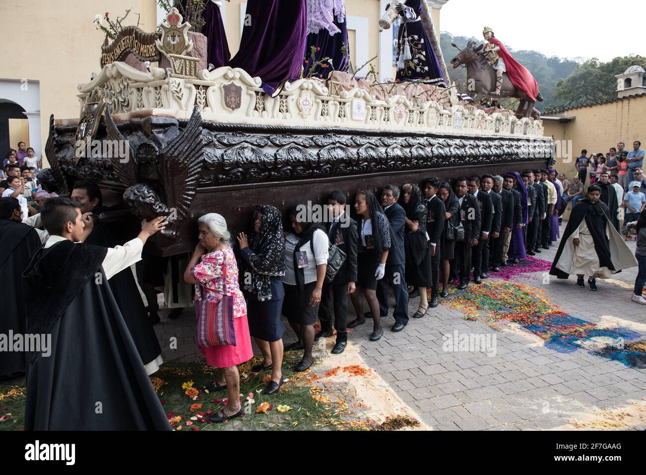 Well-dressed men in suits and women in traditional attire participate ...
