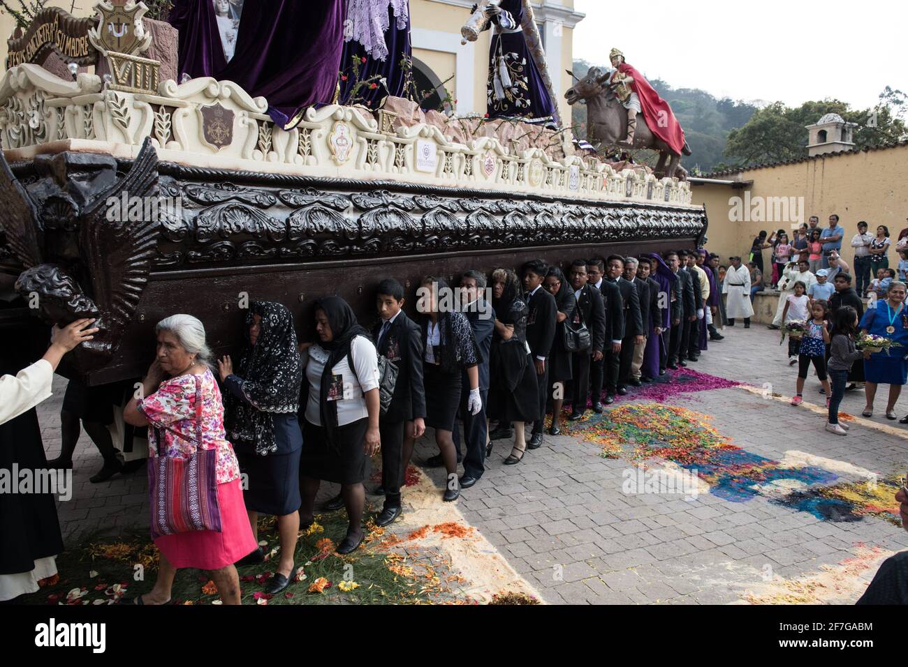 Well-dressed men in suits and women in traditional attire participate ...