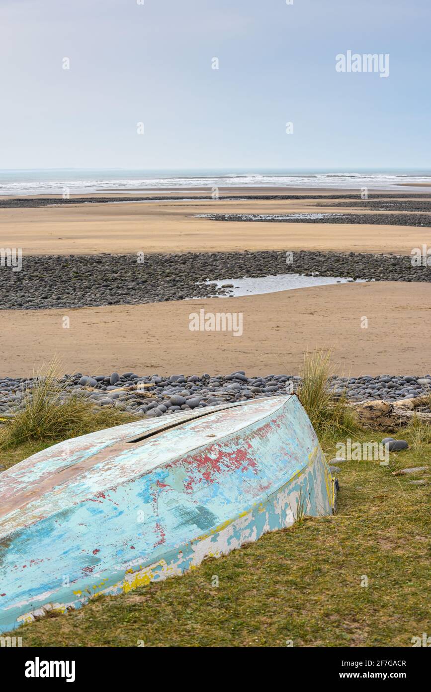 An upturned small boat washed up on the shoreline of a beautiful ...