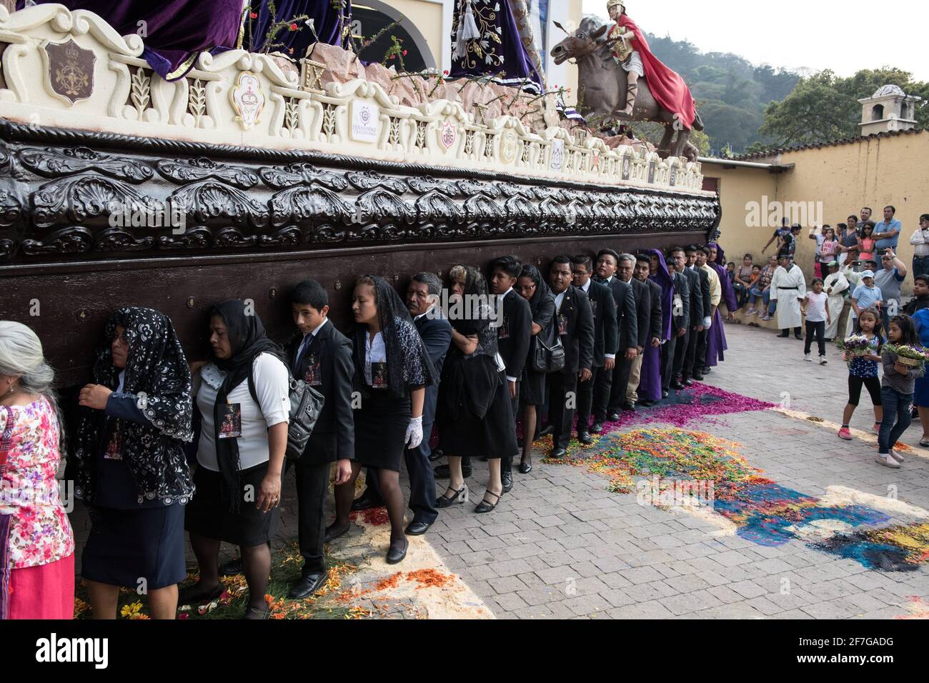Well-dressed men in suits and women in traditional attire participate ...