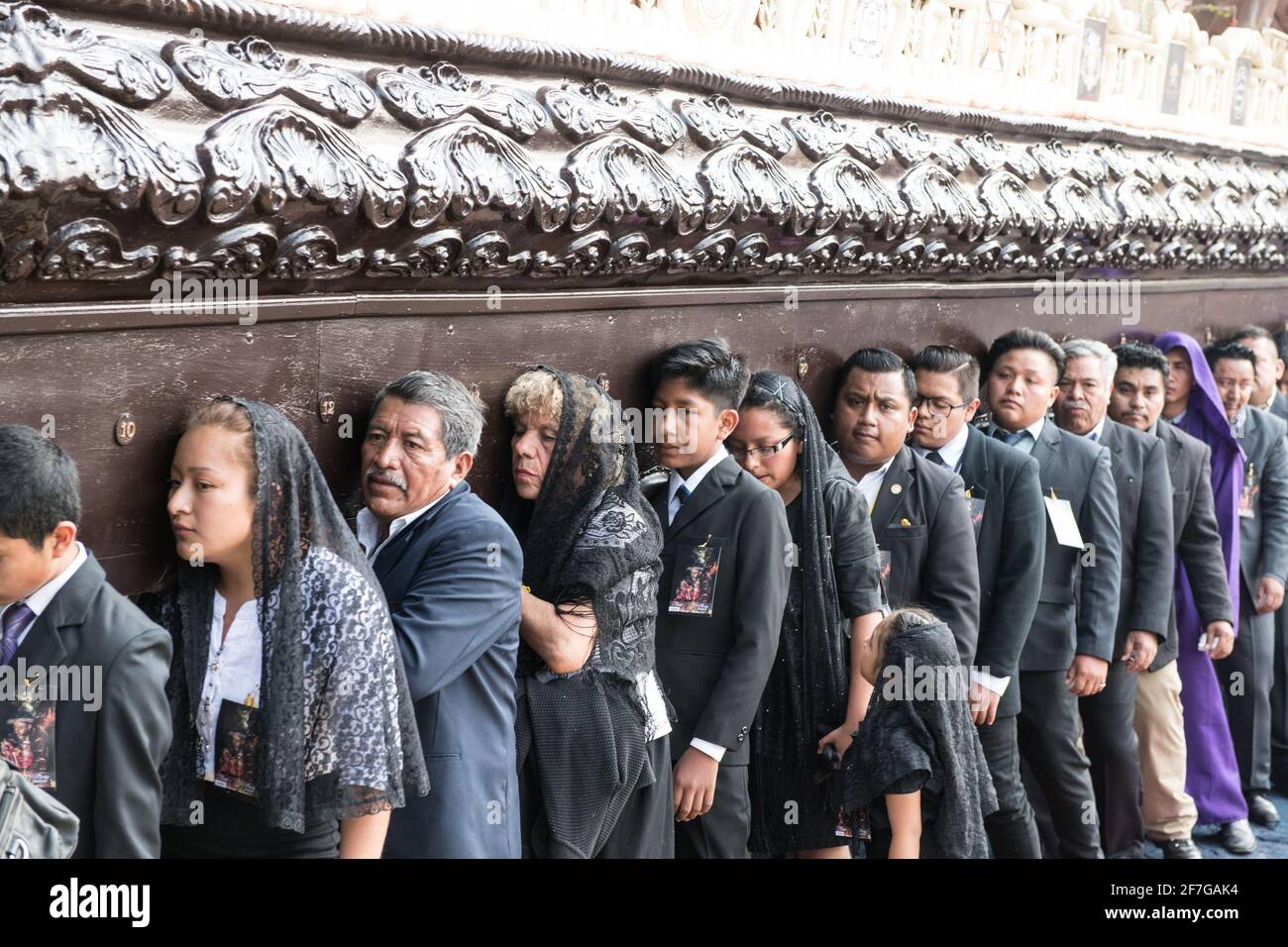 Well-dressed men in suits and women in traditional attire participate ...