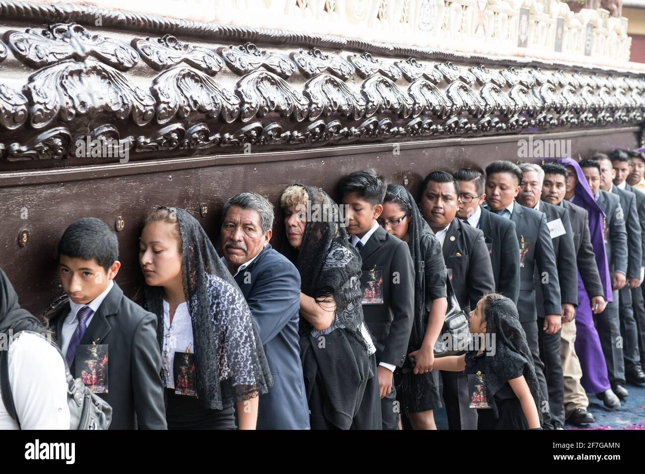 Well-dressed men in suits and women in traditional attire participate ...