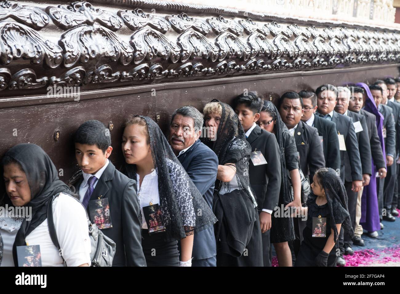 Well-dressed men in suits and women in traditional attire participate ...