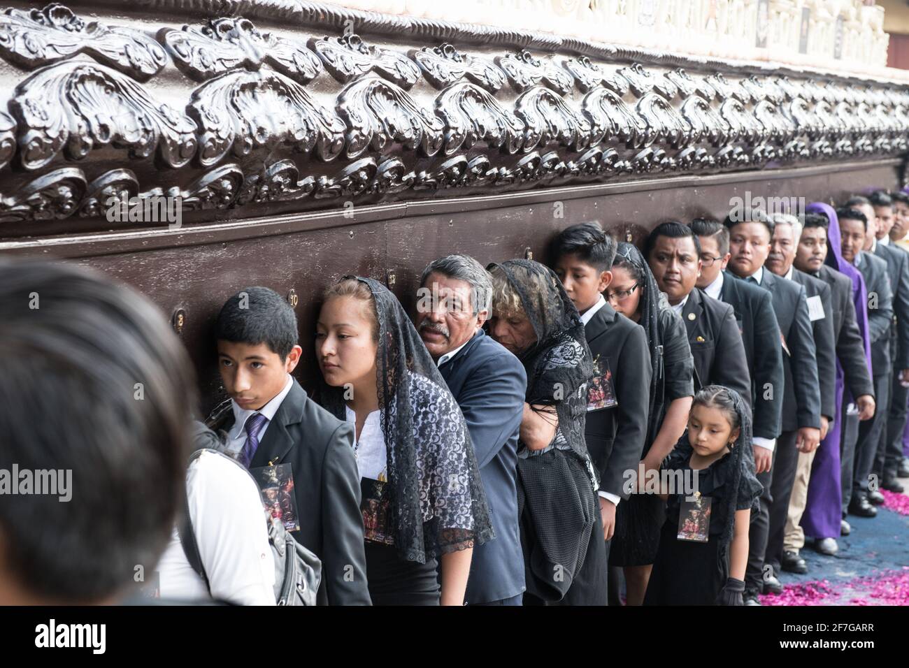 Well-dressed men in suits and women in traditional attire participate ...