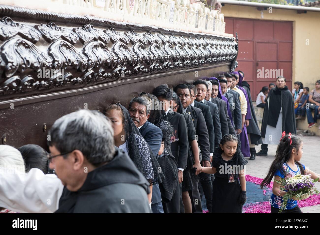 Well-dressed men in suits and women in traditional attire participate ...