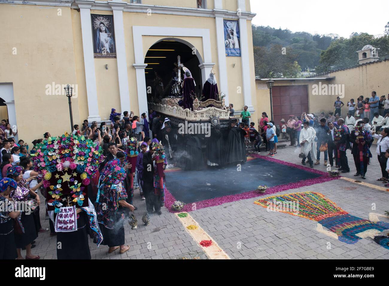 Well-dressed men in suits and women in traditional attire participate ...
