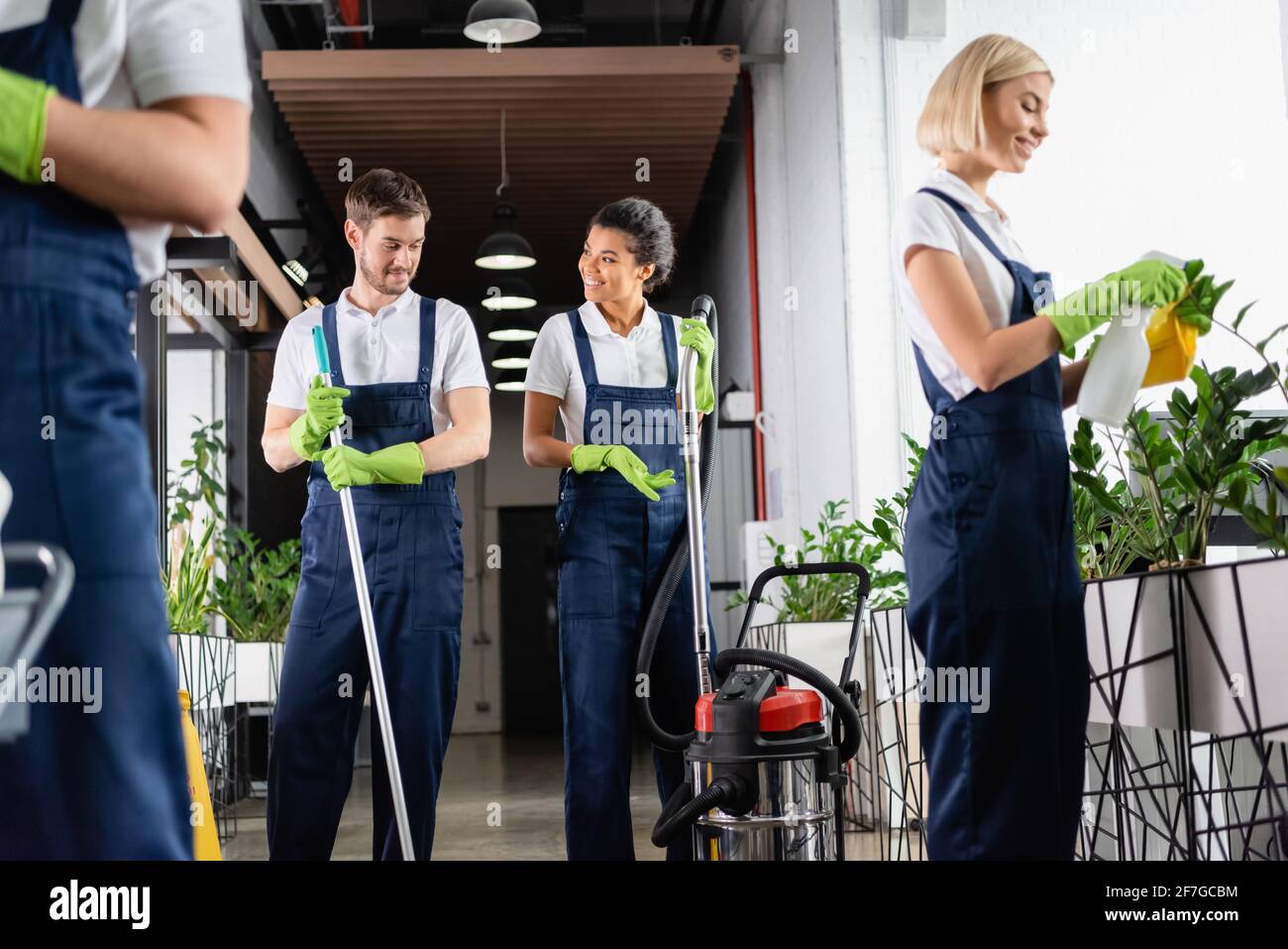 African american worker of cleaning company with vacuum cleaner talking ...