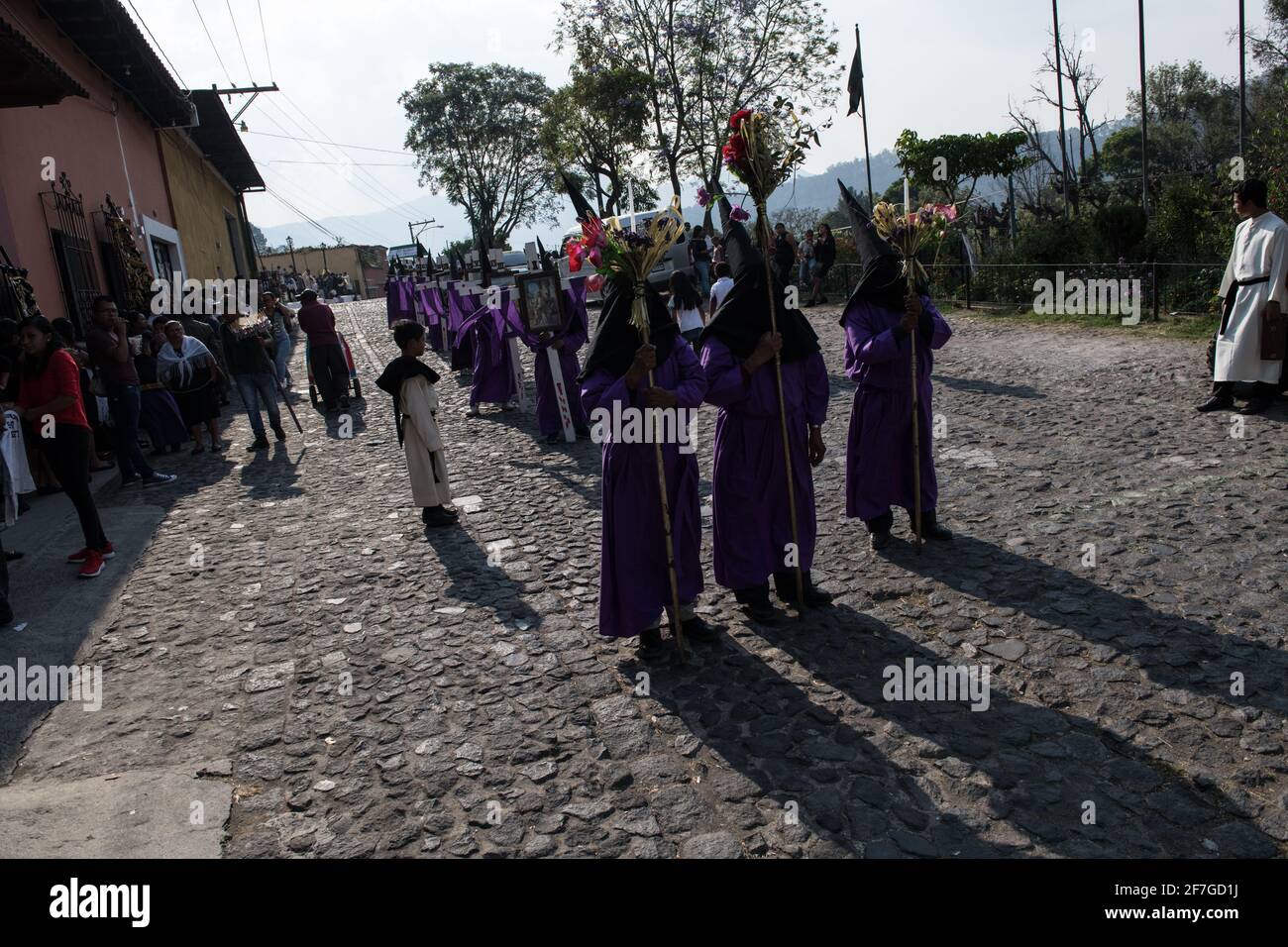 Hooded penitents carry crosses during Semana Santa procession in ...
