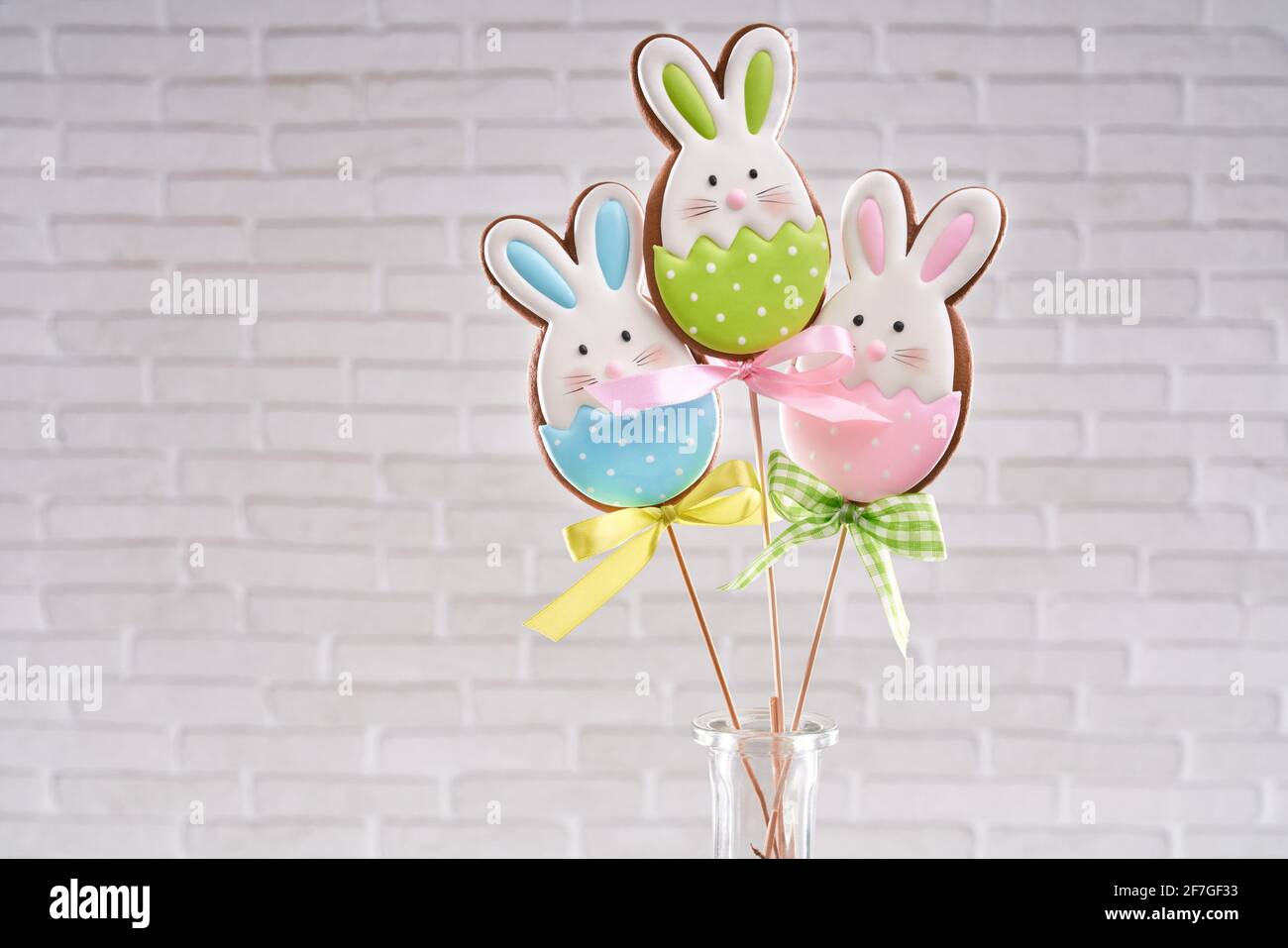 Hand painted gingerbread bunnies on wooden stick in glass vase. Tasty ...