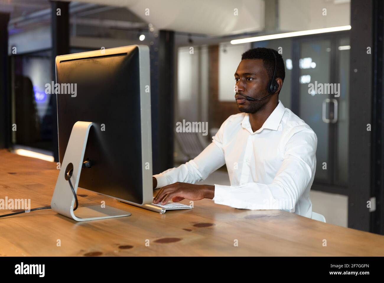 Casual african american businessman using computer sitting at desk ...