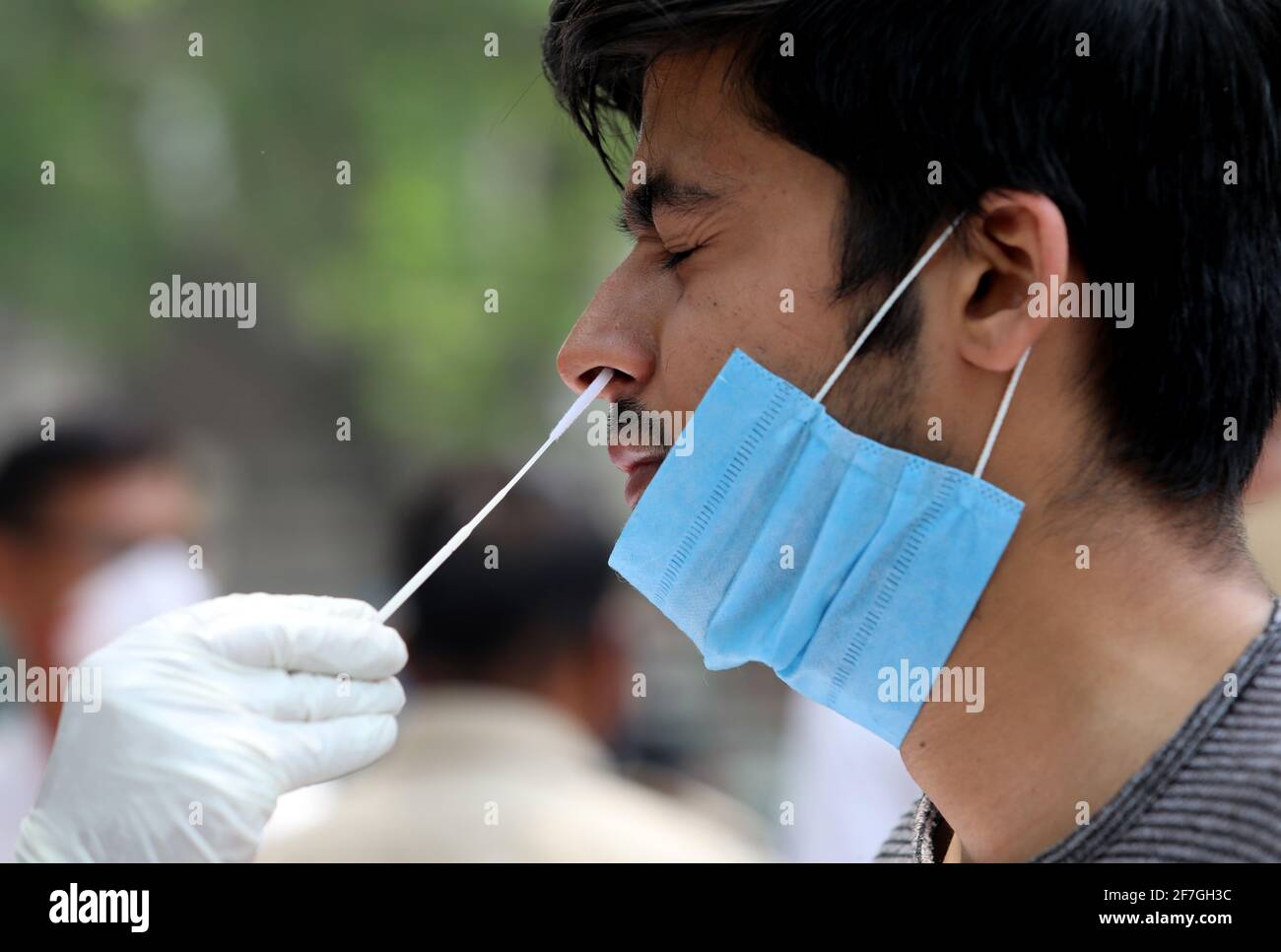 A man getting his sample collected by a health worker during swab ...