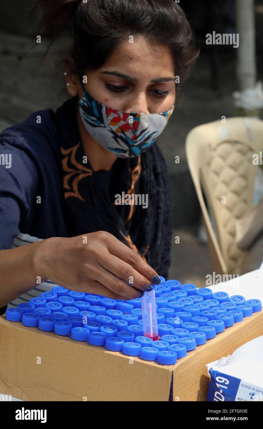 A health worker holds a test tube with samples during swab sample ...