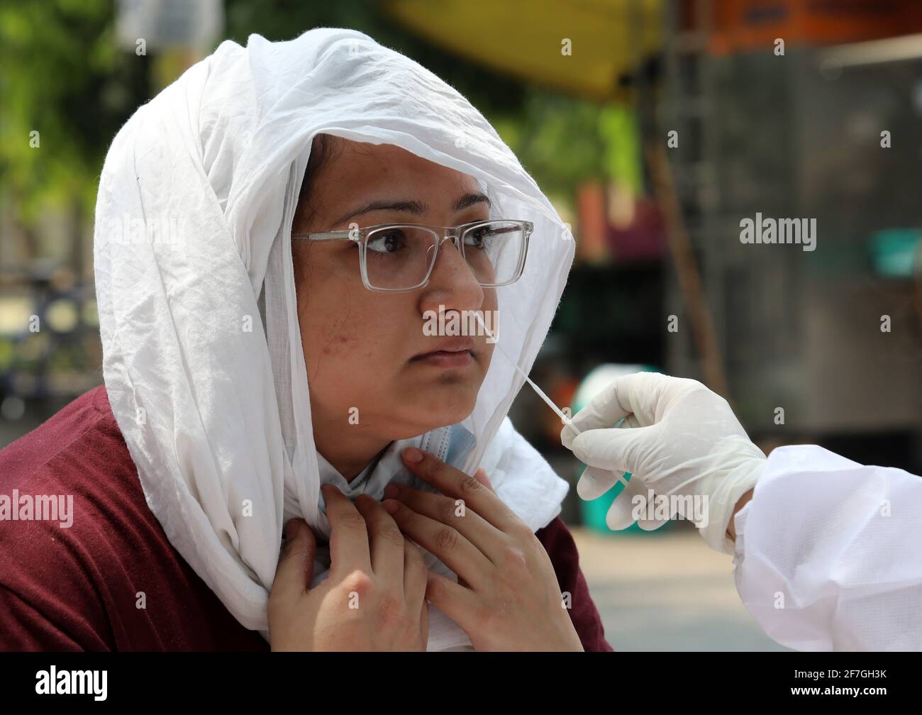 A woman getting his sample collected by a health worker during swab ...