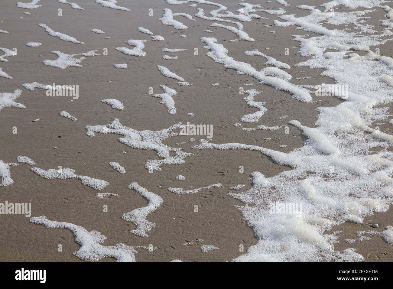 Waves with whitecaps flood the sandy beach Stock Photo - Alamy