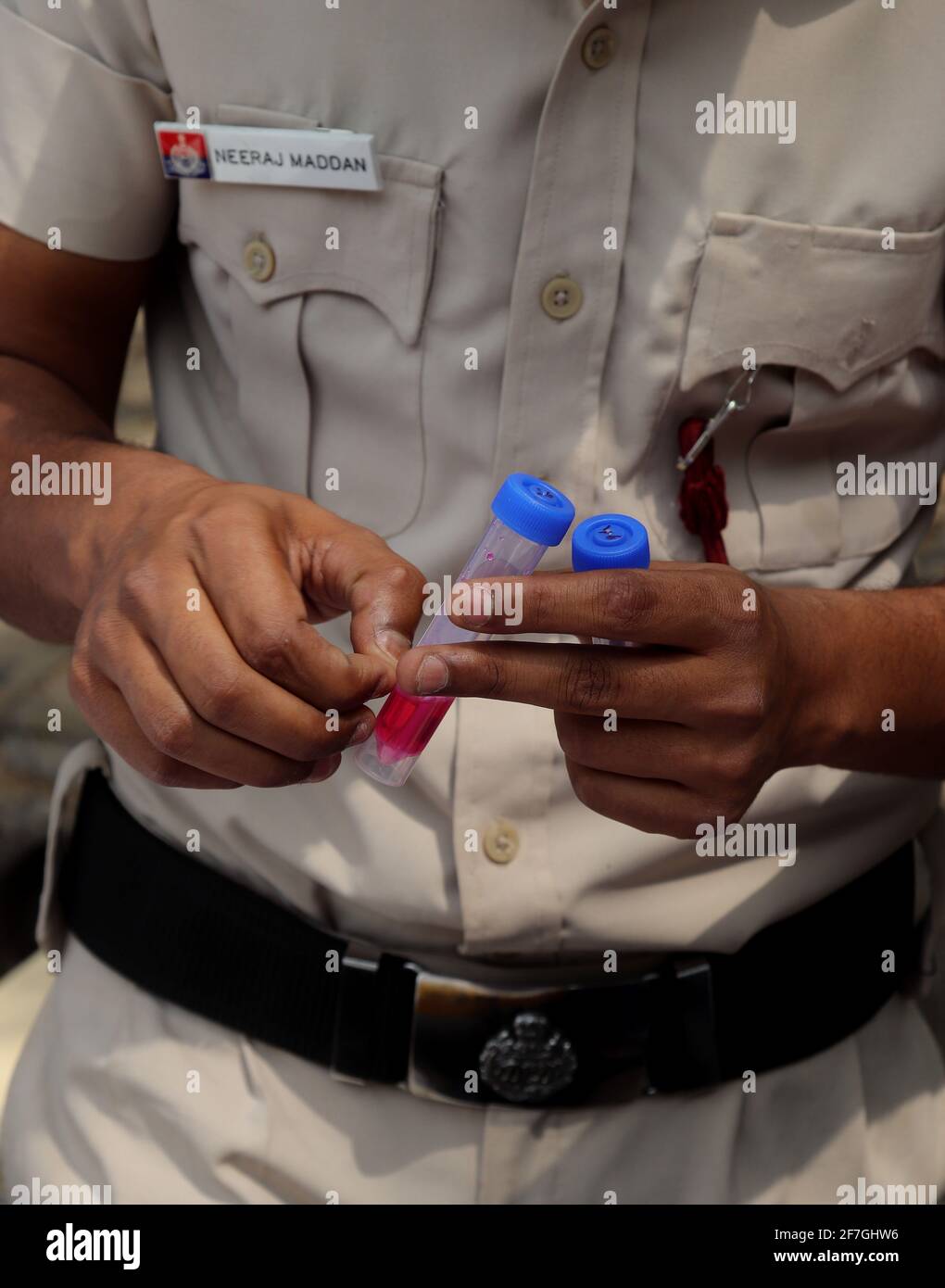 A health worker holds a sample vial during swab sample collections for ...