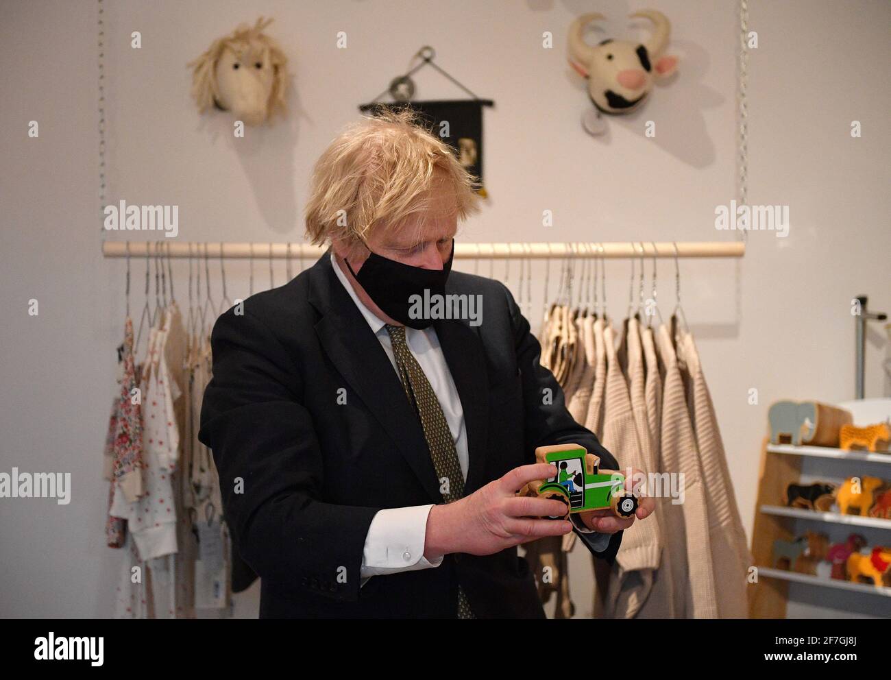 Prime Minister Boris Johnson looks at a toy tractor before purchasing ...