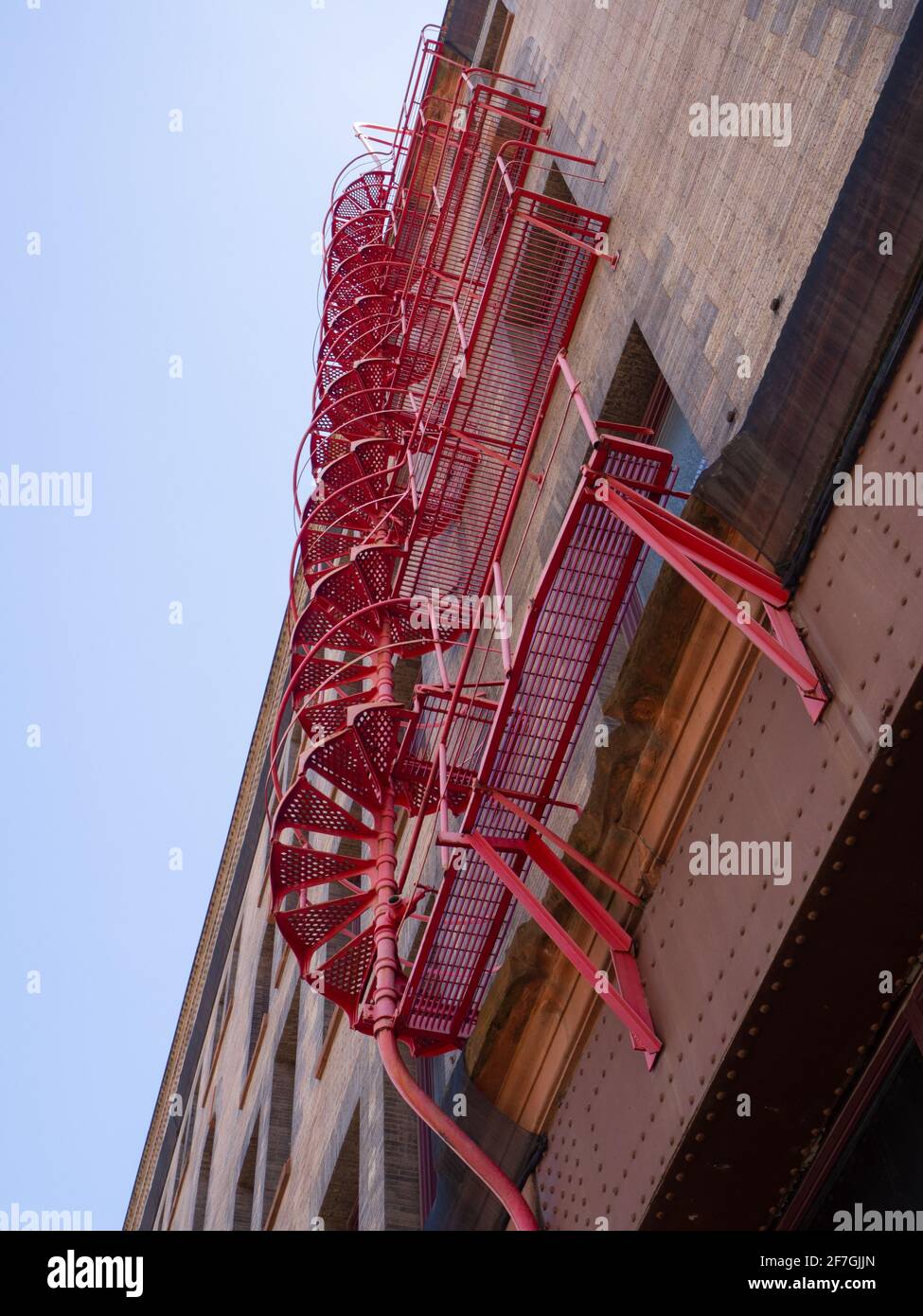 red fire escape on the side of a brick building Stock Photo - Alamy