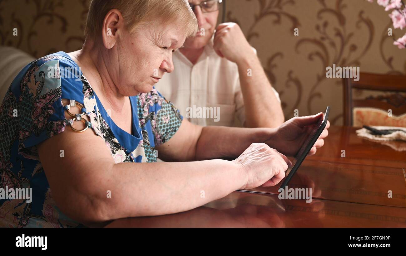 Close up of an elderly couple uses a digital tablet. Communicate ...
