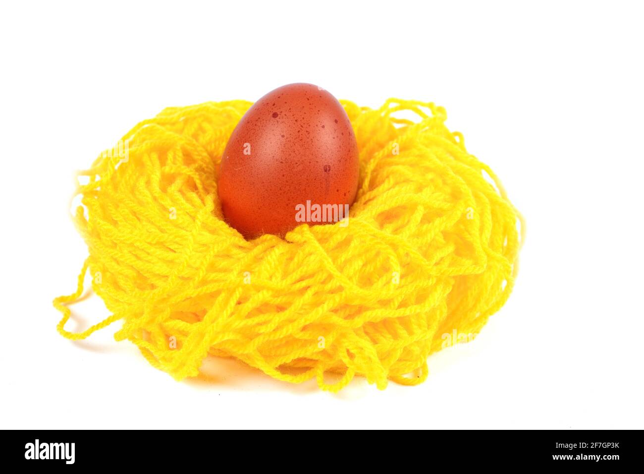 An egg in a nest, which is tied of threads on a white background Stock ...