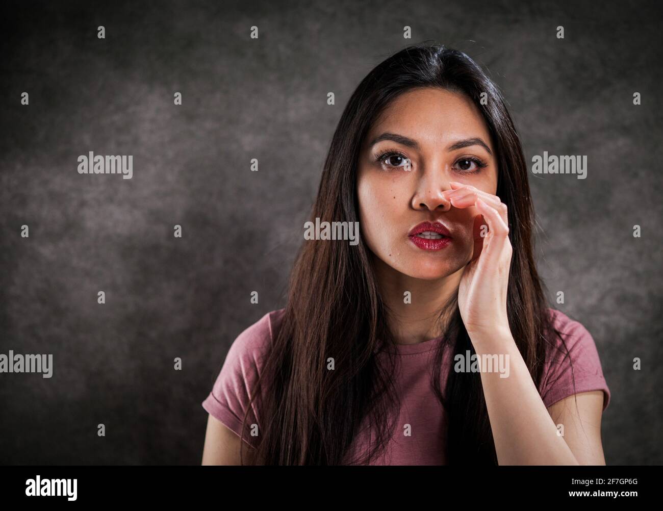 Young woman whispers something to the camera Stock Photo - Alamy