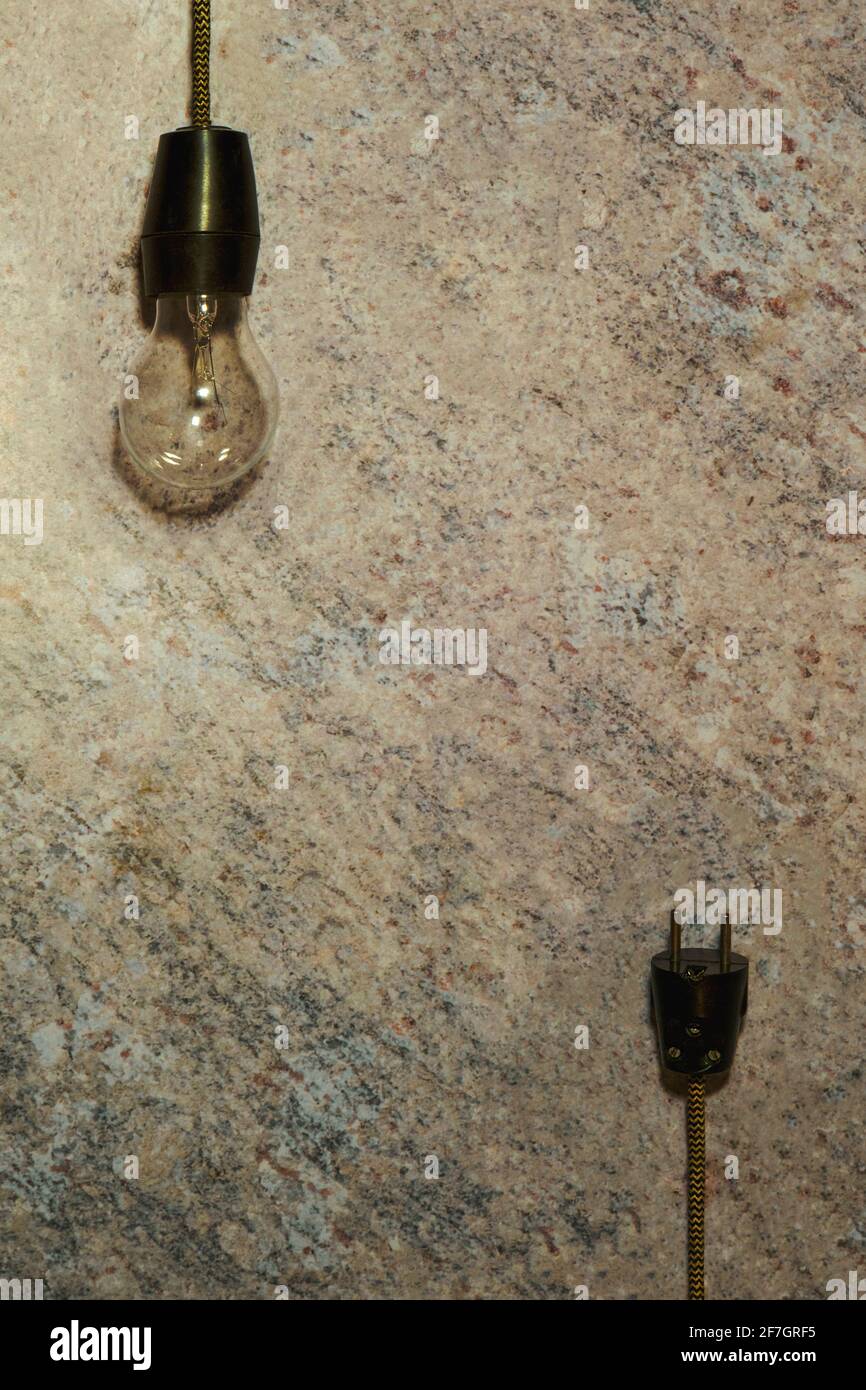 Frame formed by a vintage bulb hanging on a cable and its plug on a ...