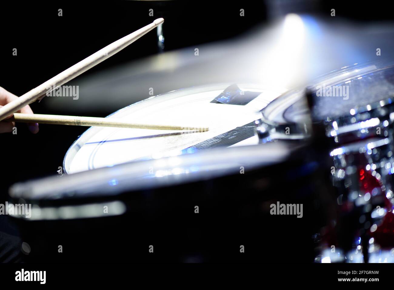 man plays musical percussion instrument with sticks closeup on a black ...