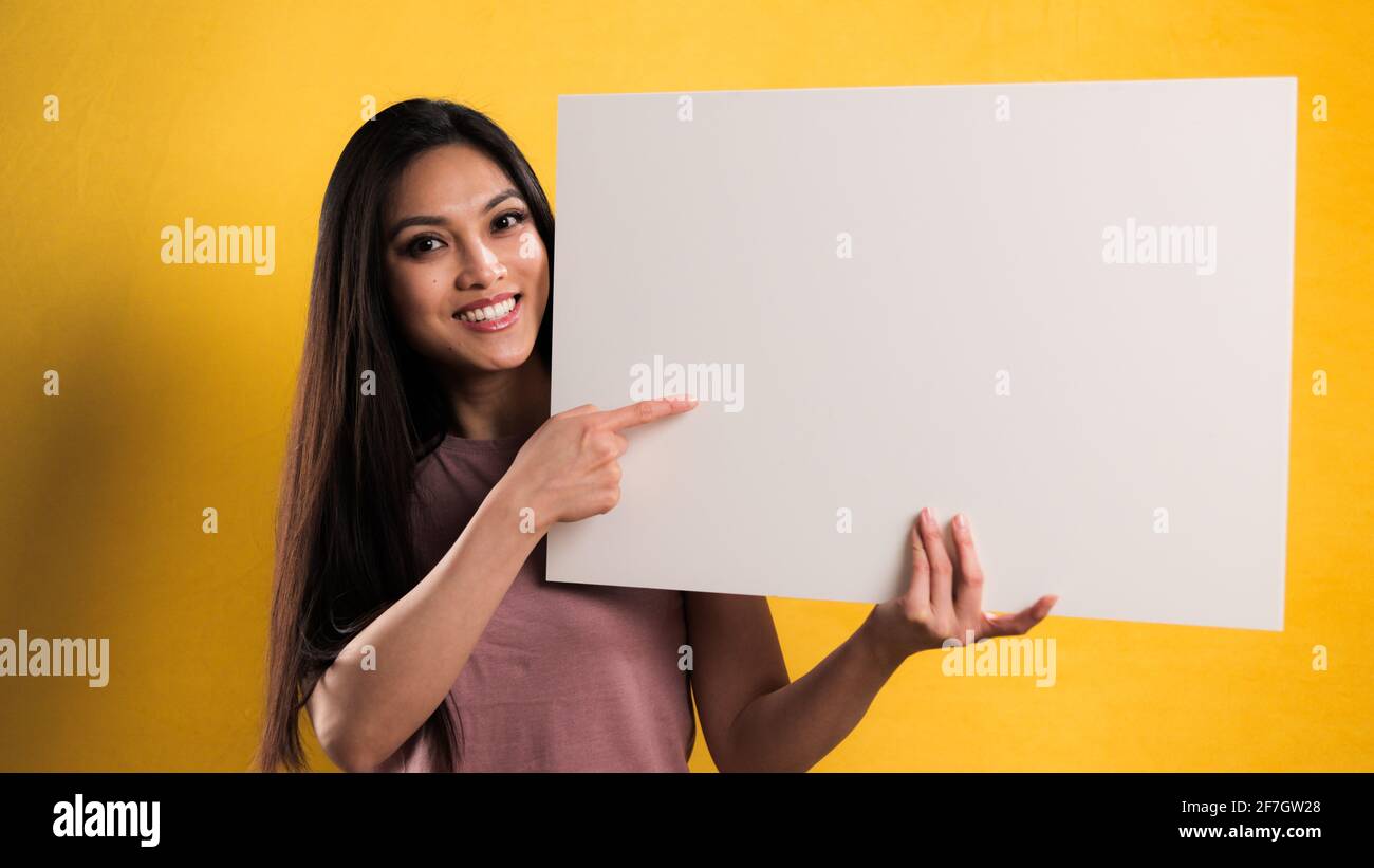 Young pretty woman points to a sign Stock Photo - Alamy