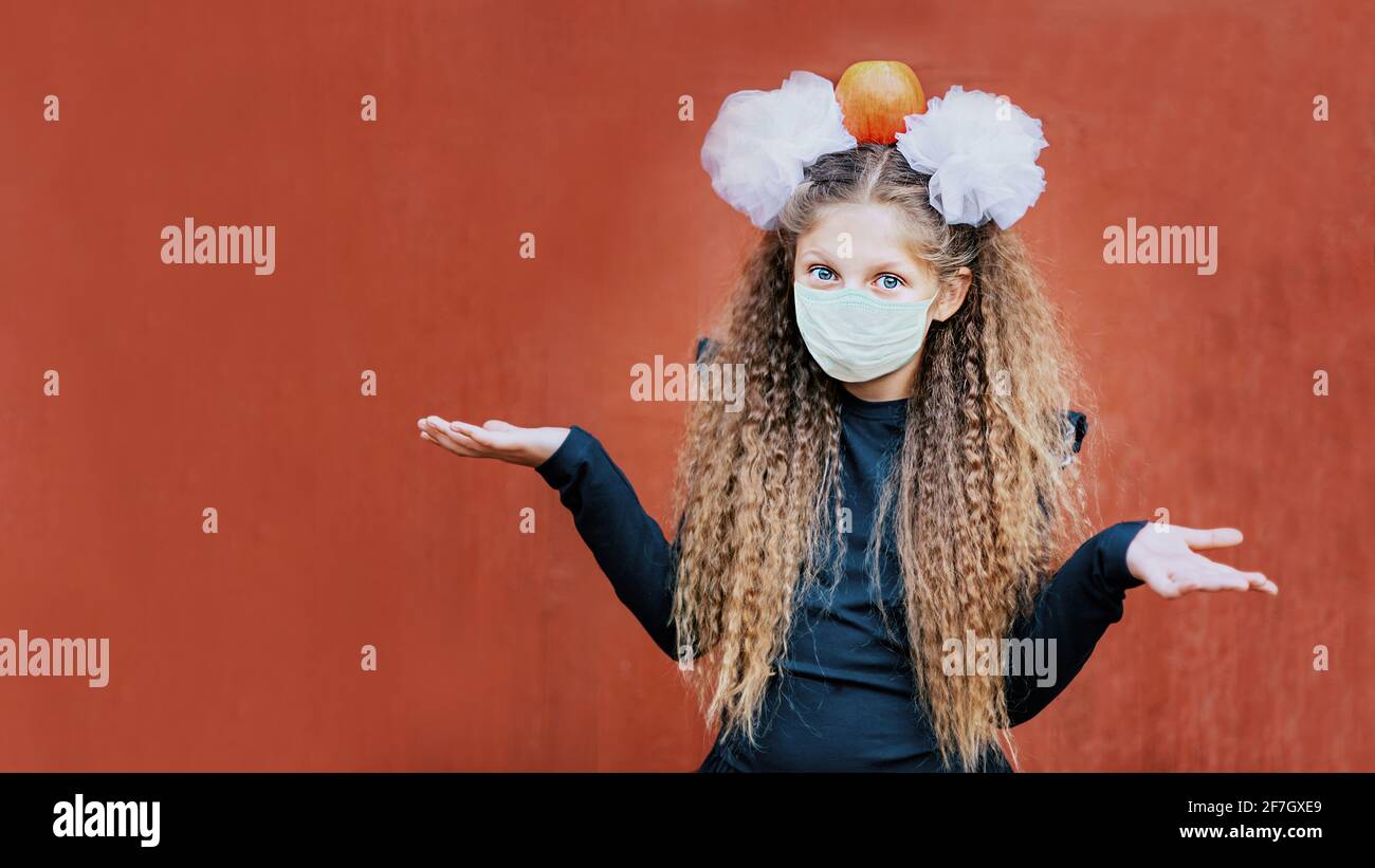 Portrait of school girl standing with red apple on head wearing ...