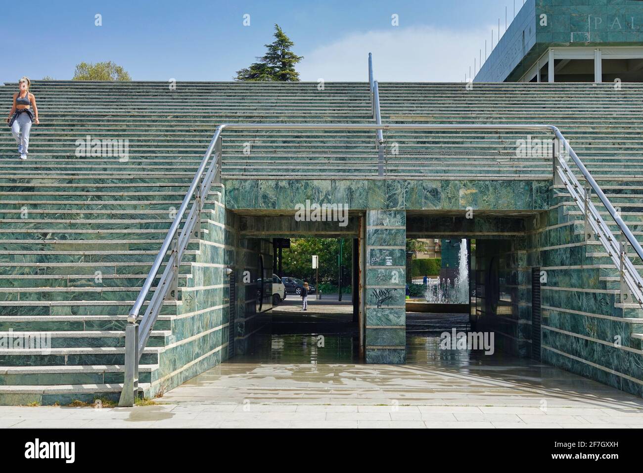 Young woman in sportswear walking down the green marble stairs of the ...