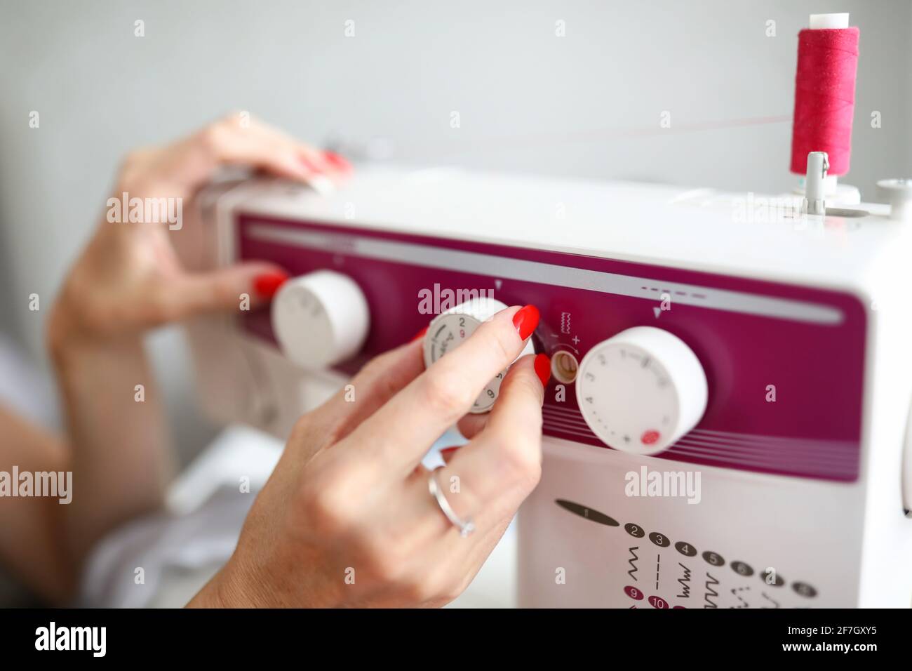 Female hands adjust the relay on sewing machine Stock Photo - Alamy