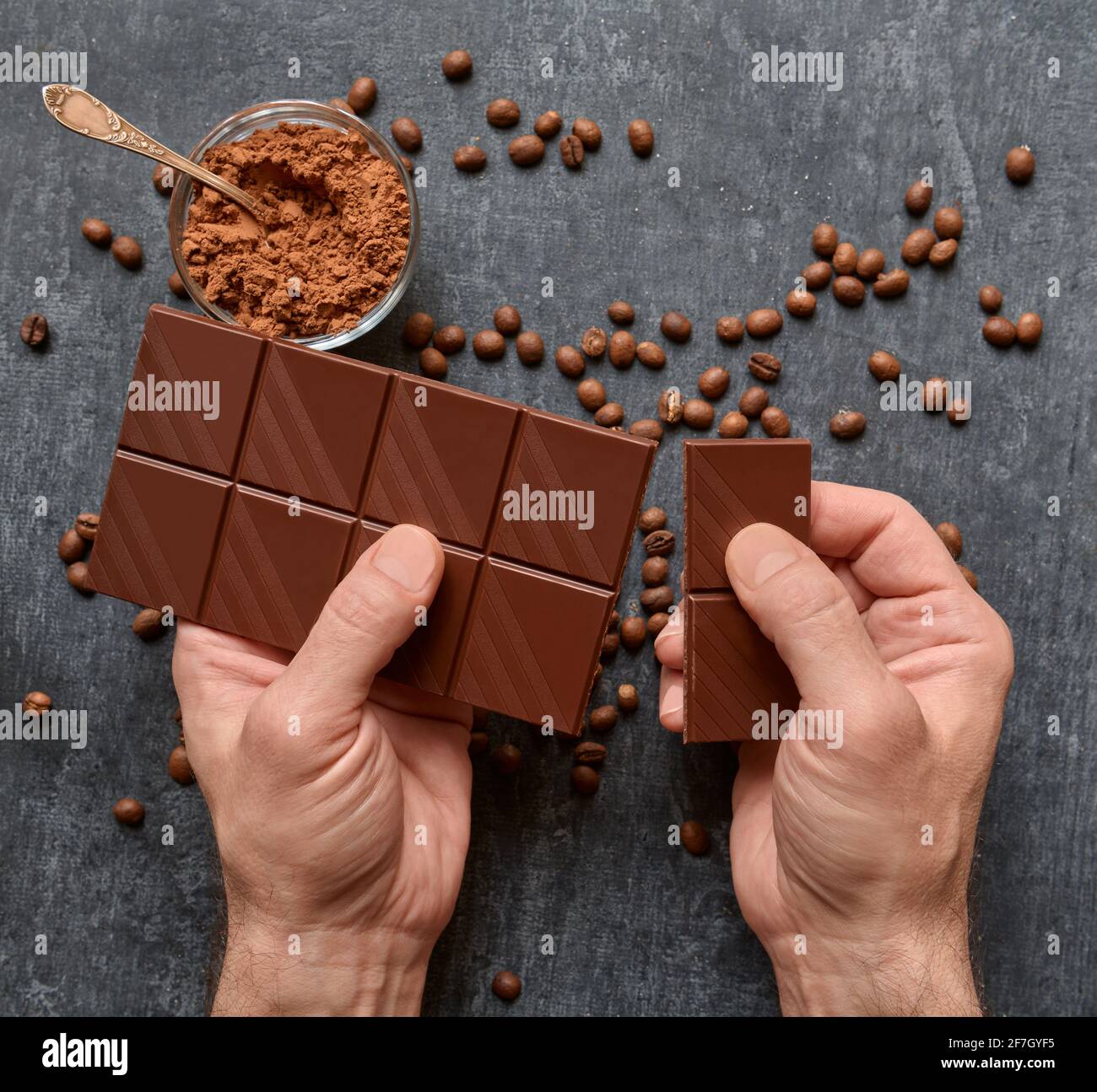 Closeup male hands breaking a bar of chocolate Stock Photo - Alamy