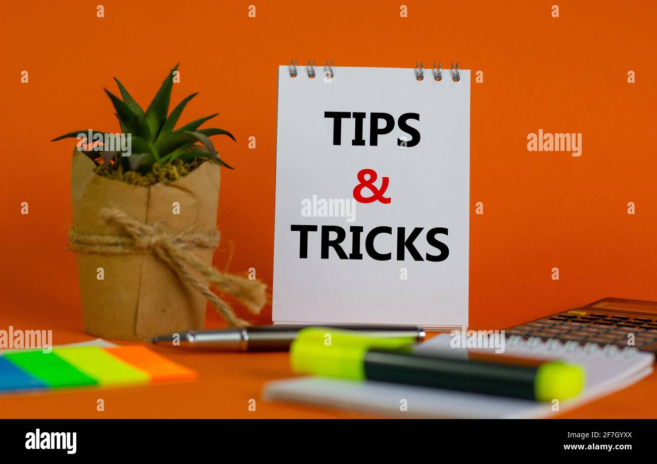 Tips and tricks symbol. White note with words tips and tricks on ...