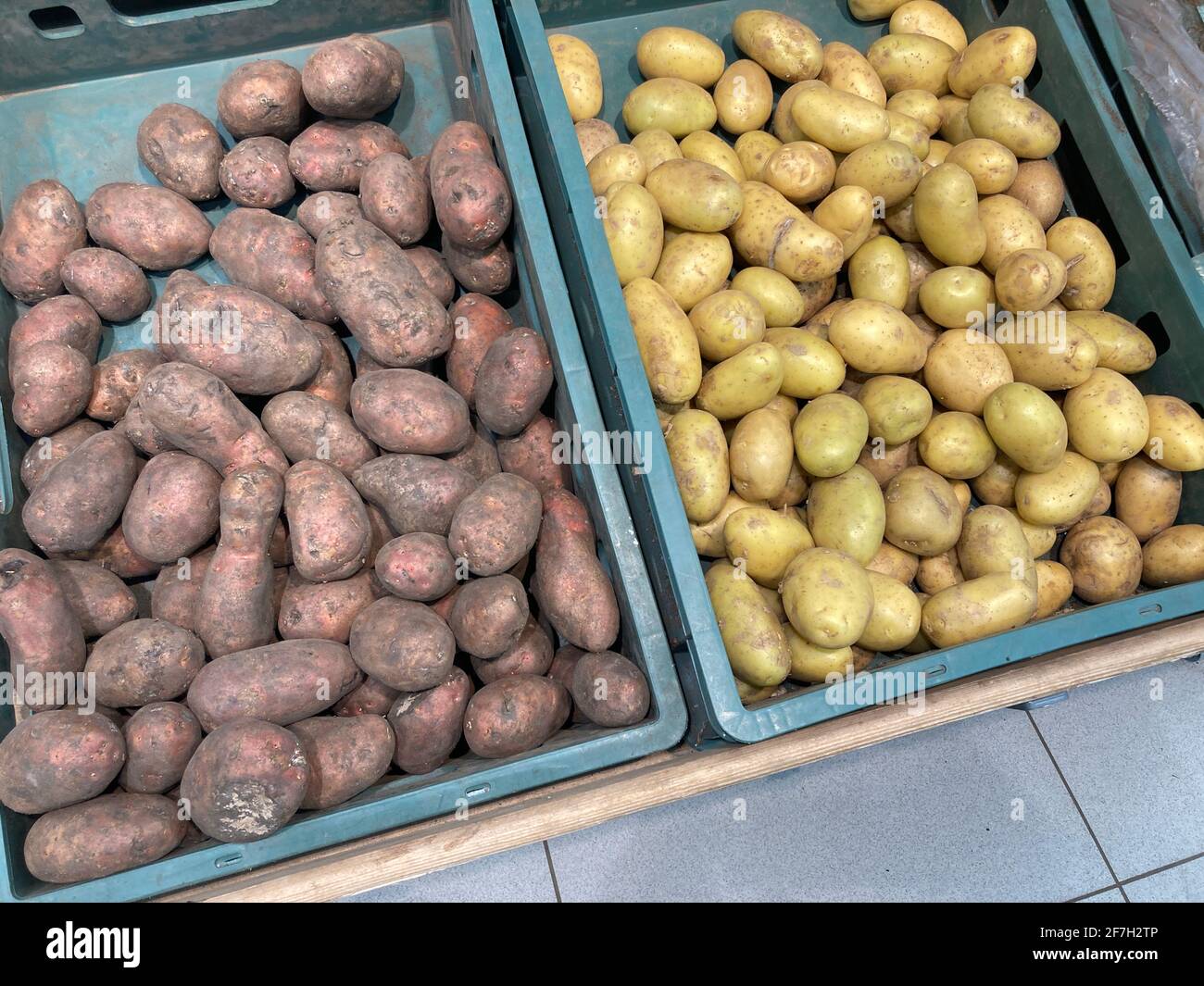 Close up of various potatoes in plastic boxes on supermarket counter ...