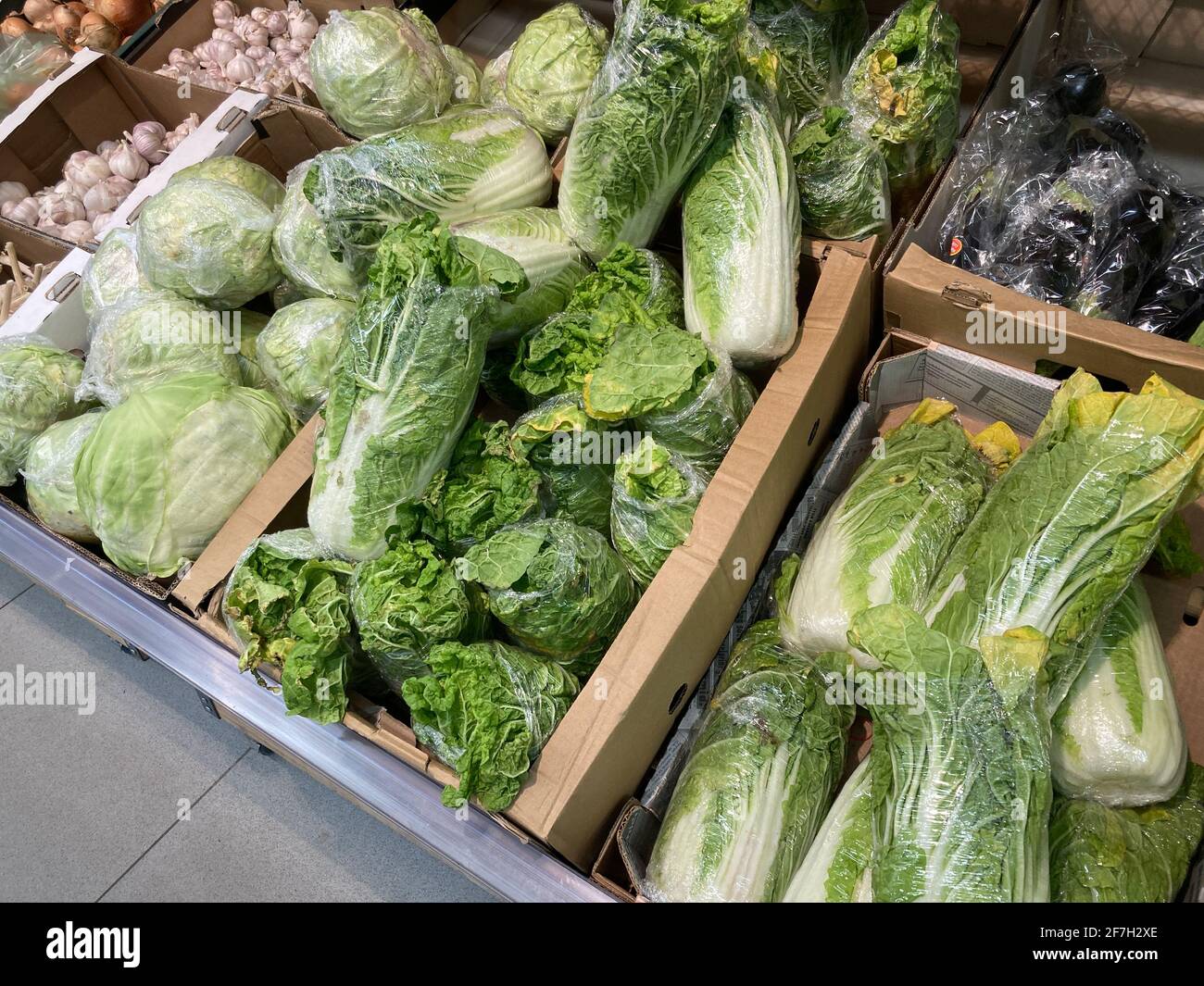Close up of various cabbage in cardboard boxes on supermarket counter ...
