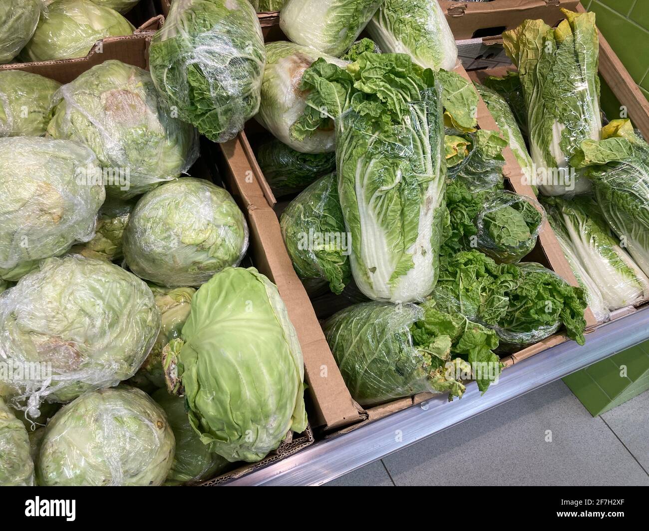 Close up of various cabbage in cardboard boxes on supermarket counter ...
