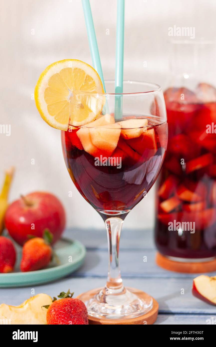 View of a glass and bottle of sangria with a fruit plate in vertical ...