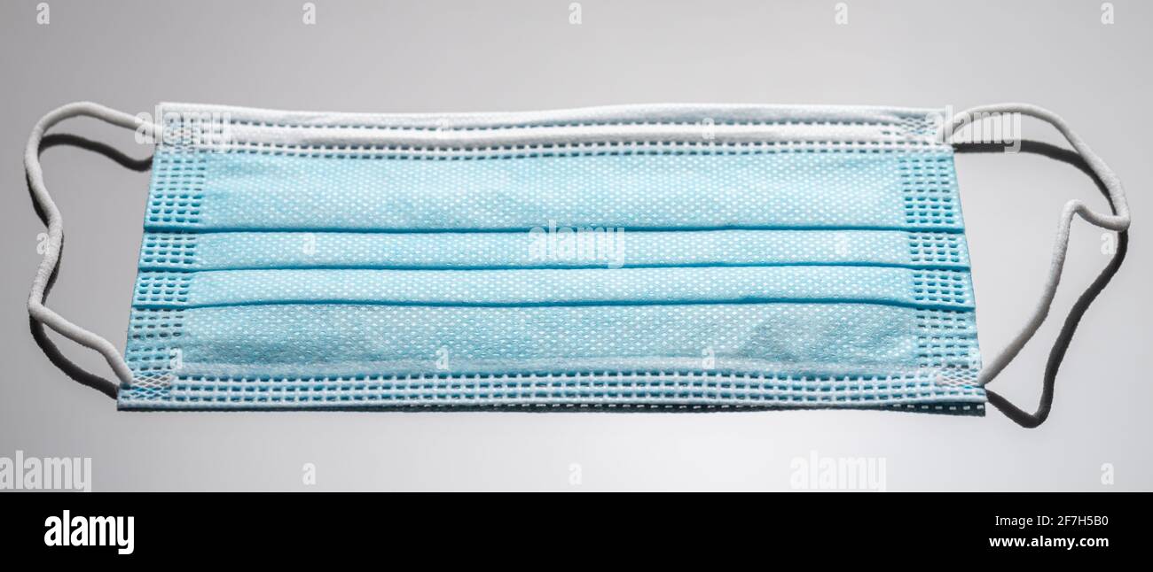 Surgical mask with rubber ear straps. A typical three-layer surgical ...