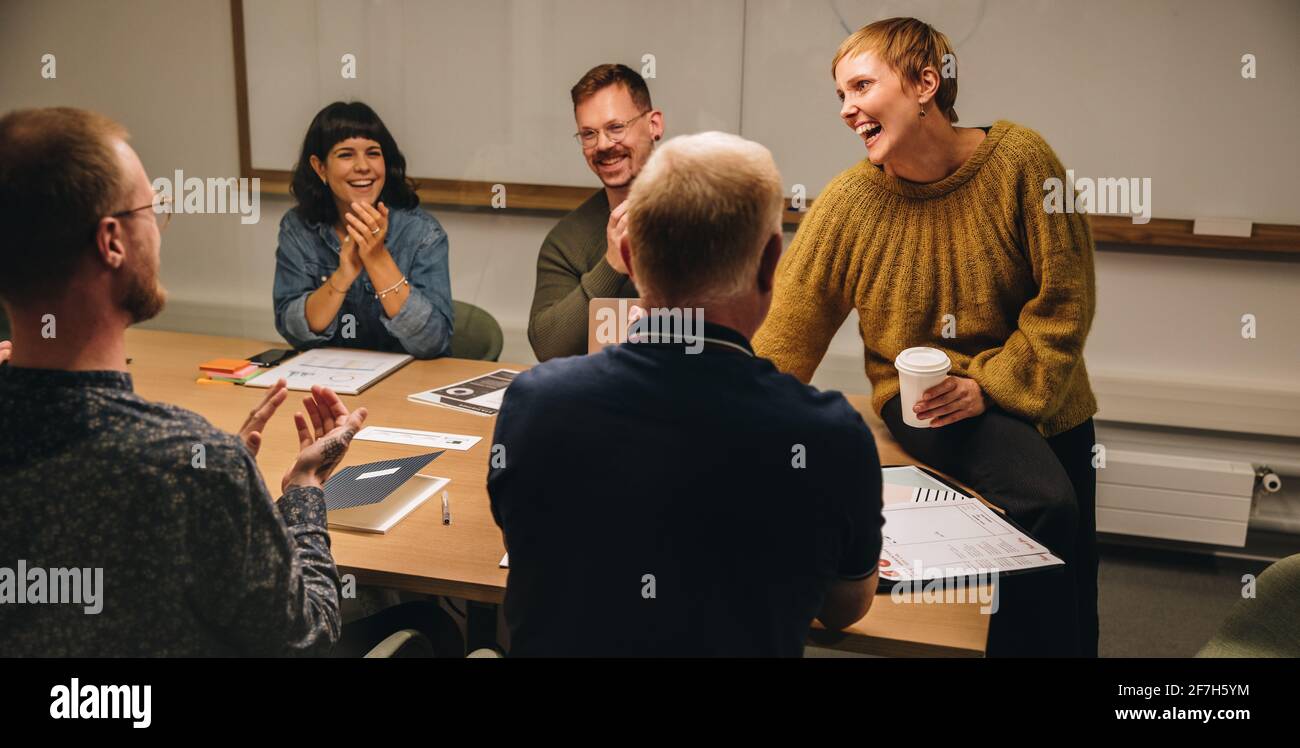 business team smiling during meeting in office. businesswoman sharing ...
