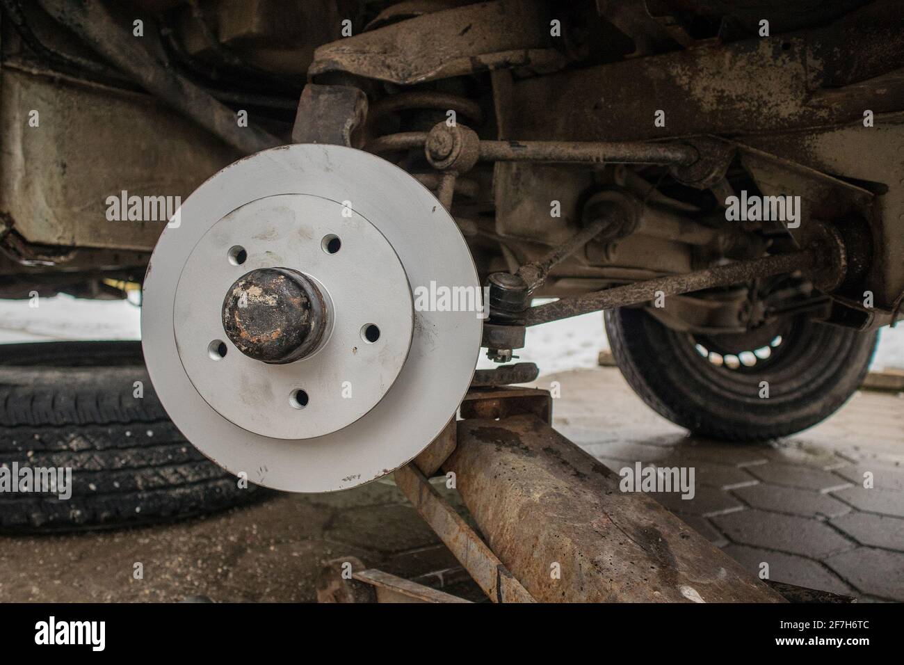 New shiny gray or silver brake disc freshly installed on an old car ...