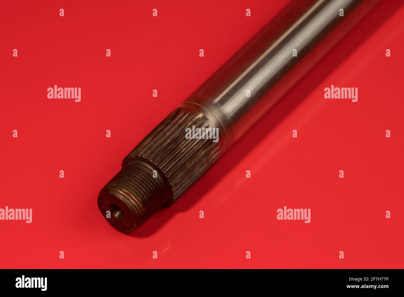 Detail or close up of a chrome axle with splines and thread on the end ...