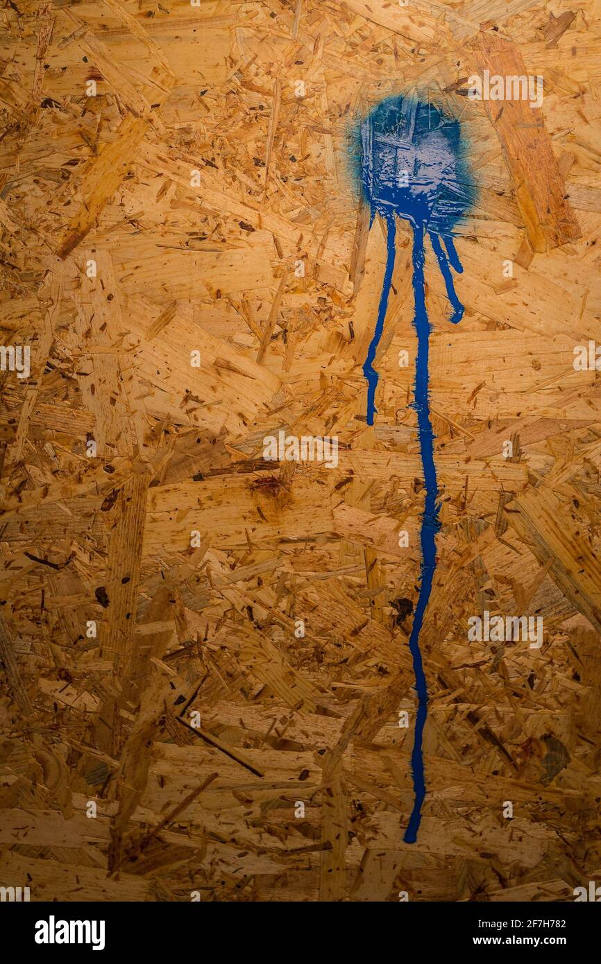 Dirty OSB wood board. OSB panel board with a splat of red paint on it ...