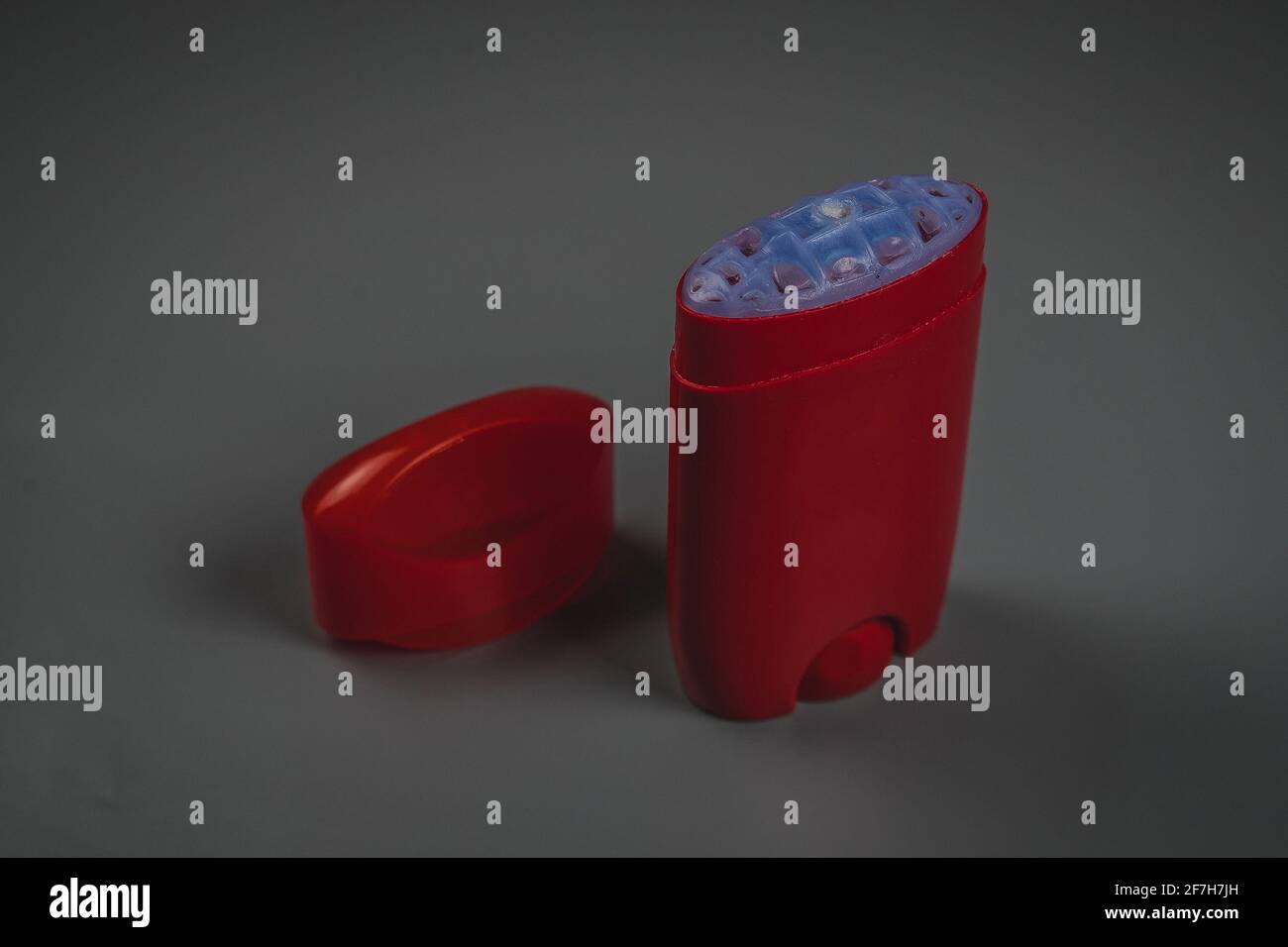 Empty red deodorant stick with open top on a gray background. Visible ...