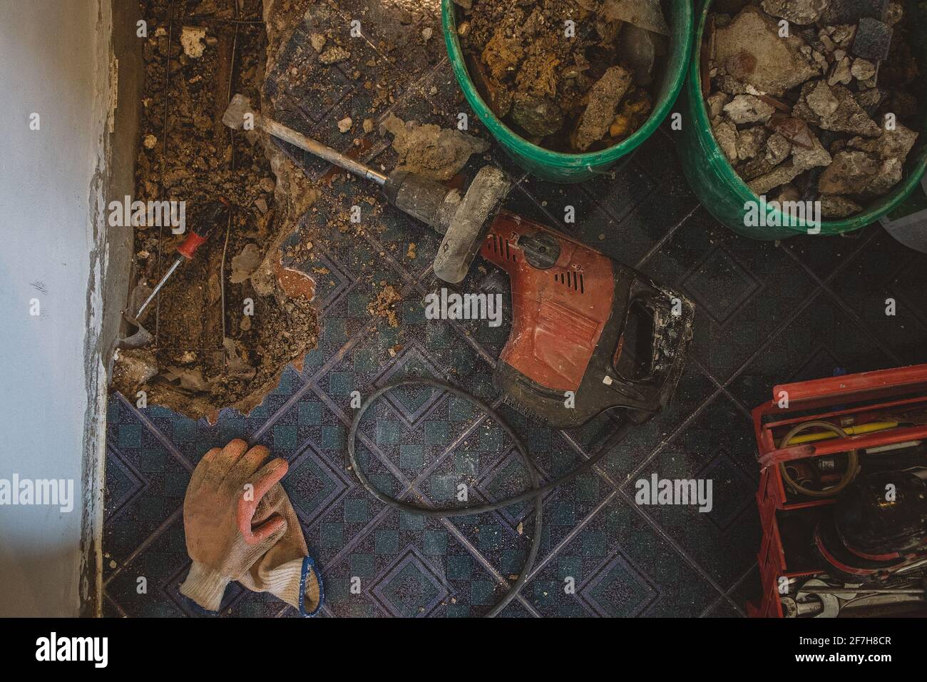 Red electric demolition hammer on the floor, while renovating an old ...