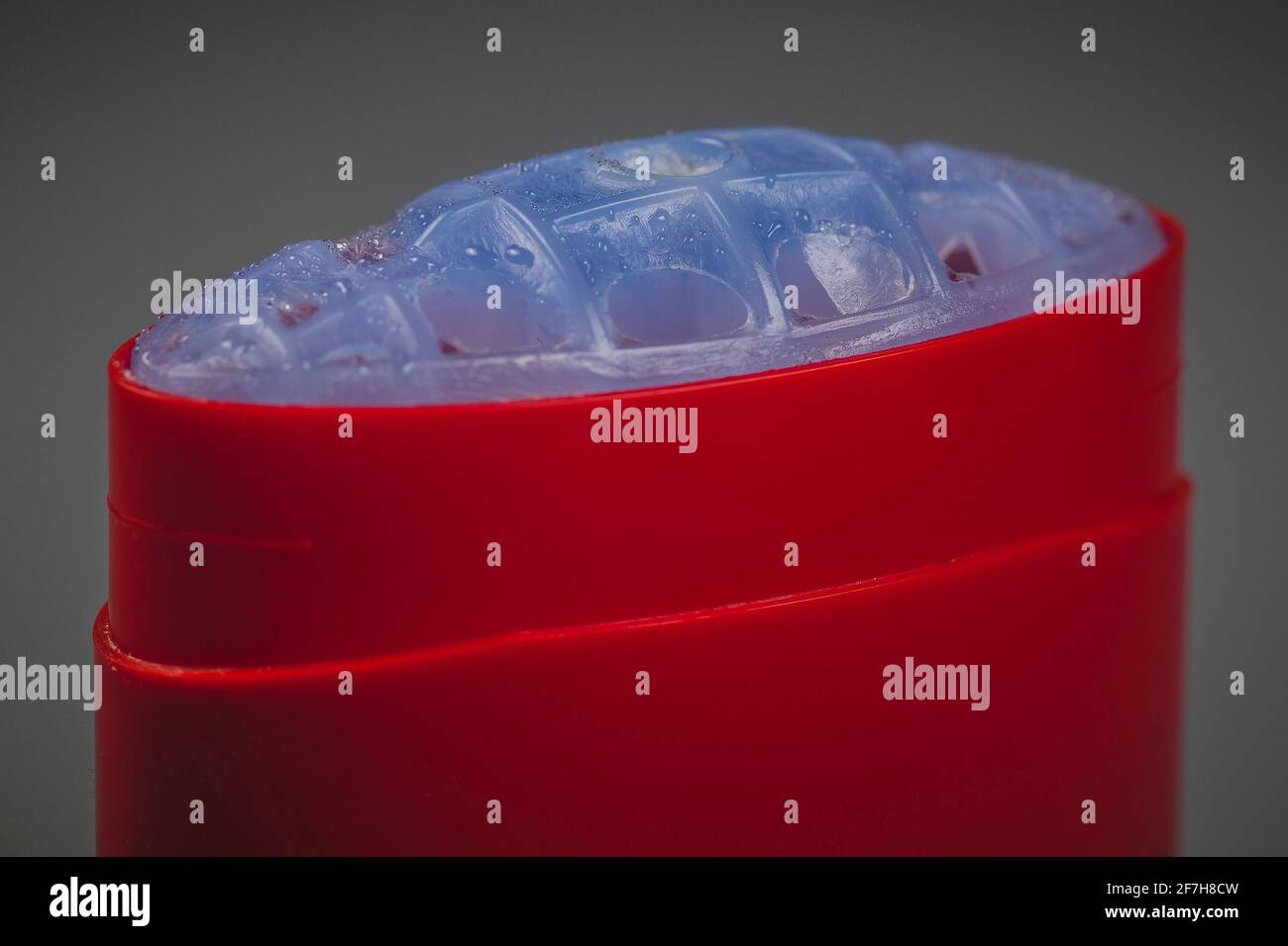 Empty red deodorant stick with open top on a gray background. Visible ...