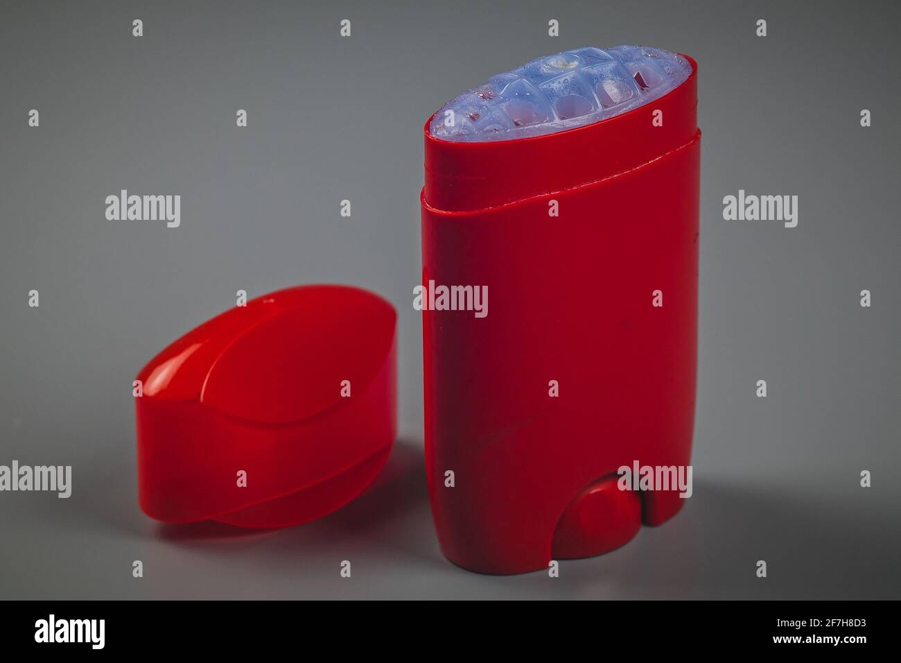 Empty red deodorant stick with open top on a gray background. Visible ...
