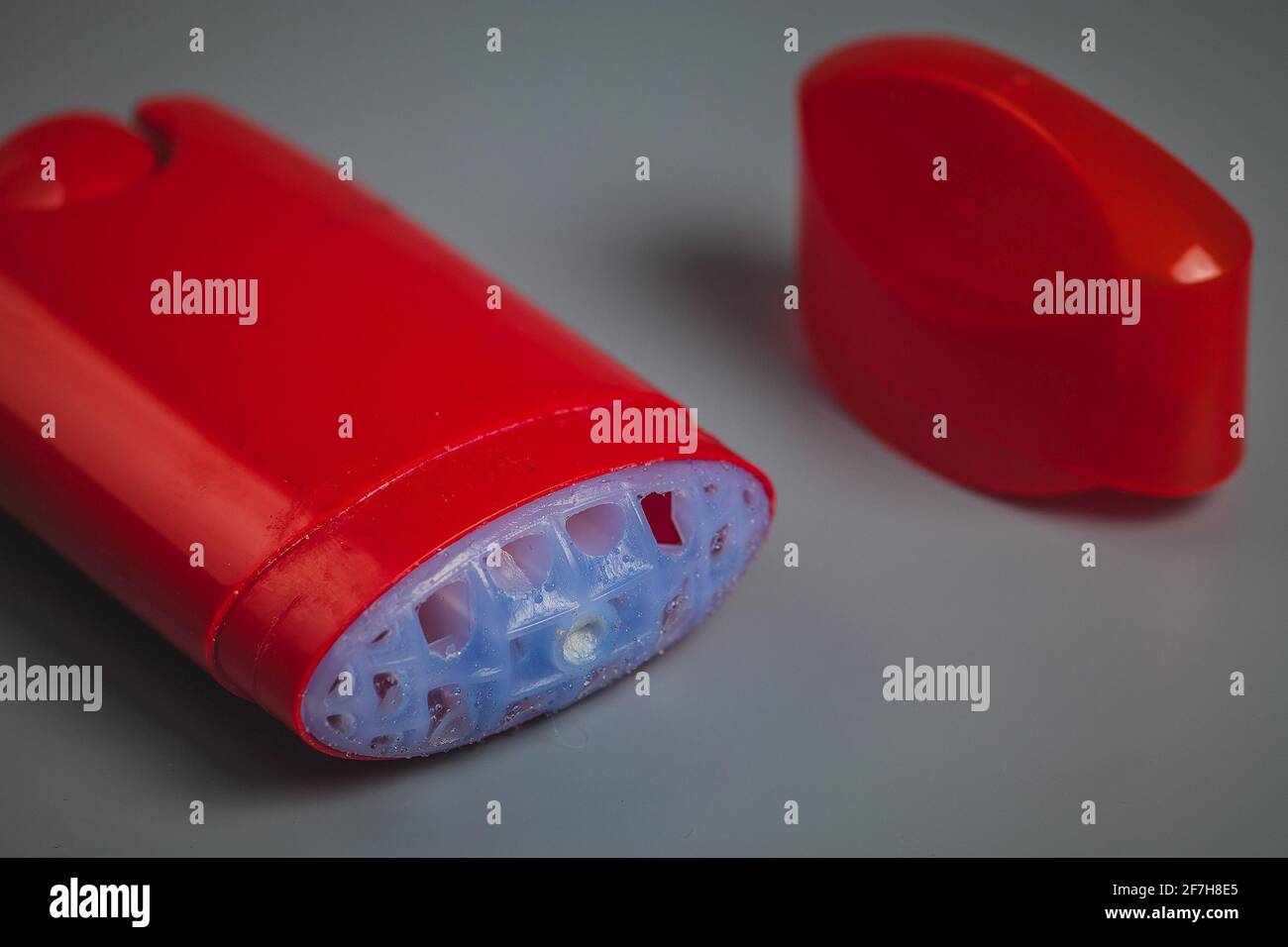 Empty red deodorant stick with open top on a gray background. Visible ...