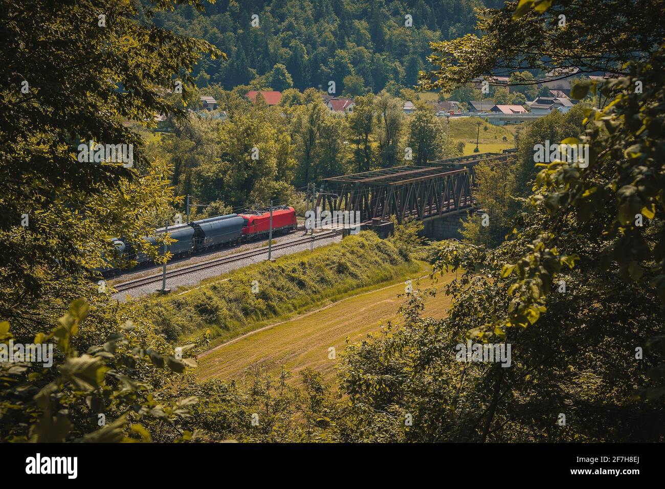 European freight train with red locomotive is driving on a two track ...