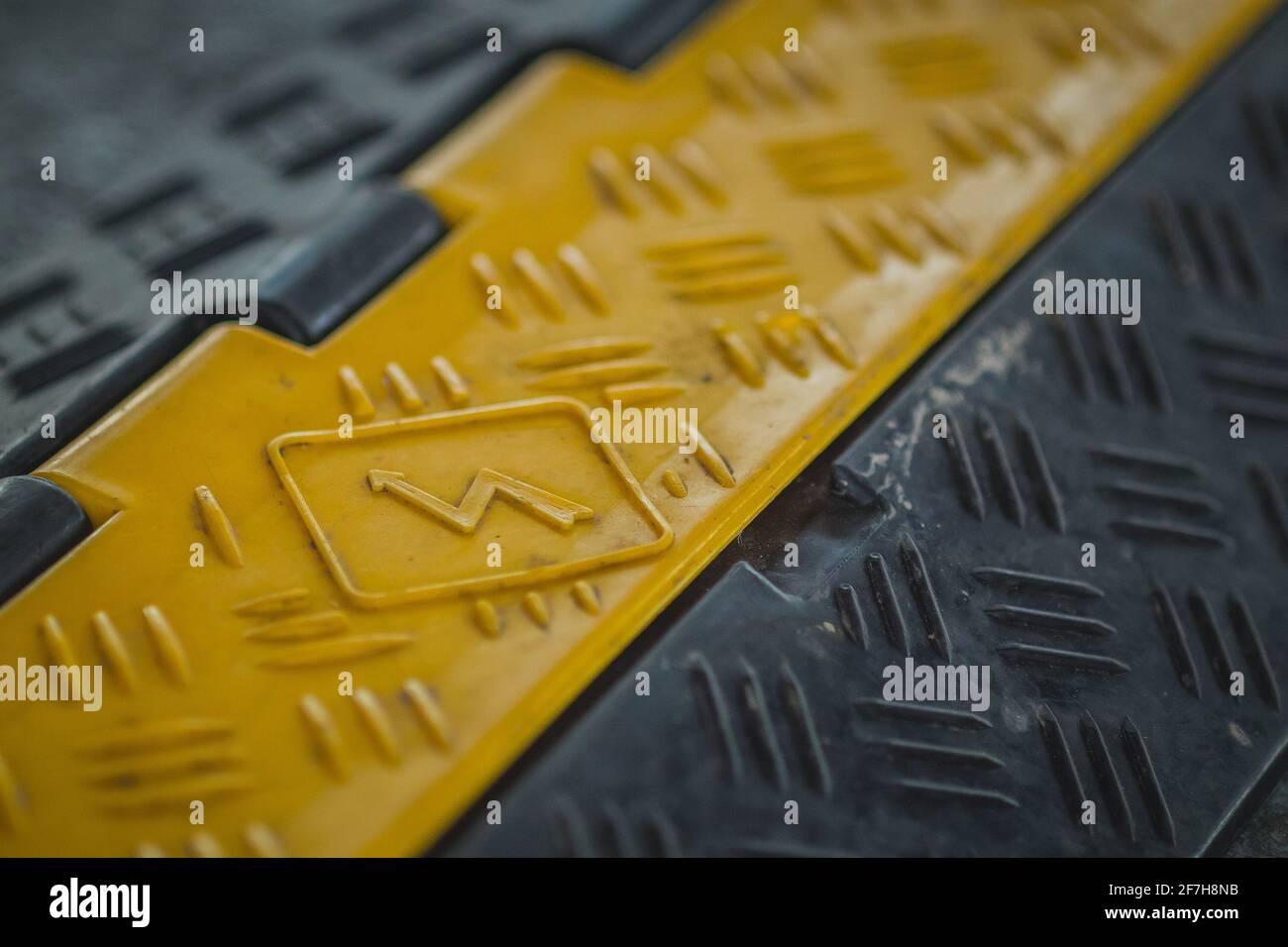 Black and yellow plastic cable protector on the ground. Floor cable ...