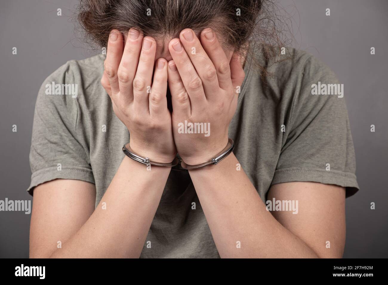 the criminal hides his face and regrets,woman handcuffed regrets her ...